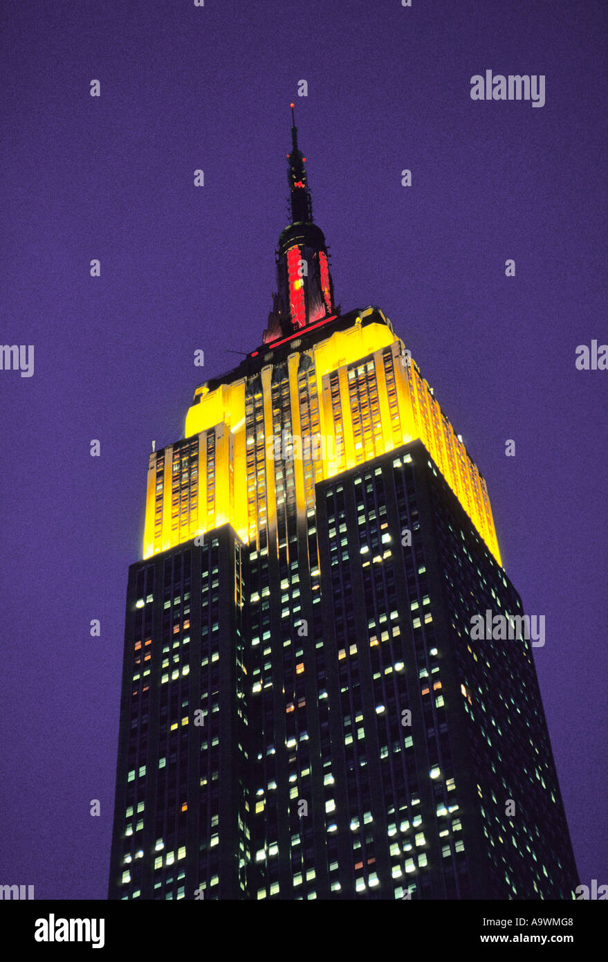 Empire State Building in New York City, close up at night. Yellow and ...
