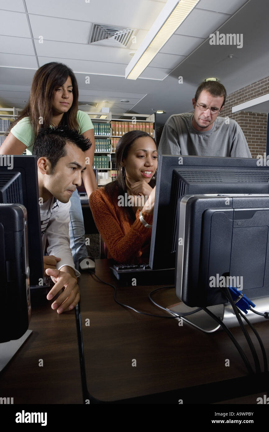 Young students using computers in the library Stock Photo - Alamy