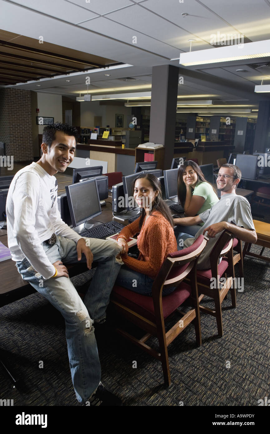 Portrait of students sitting together while using computers in the ...