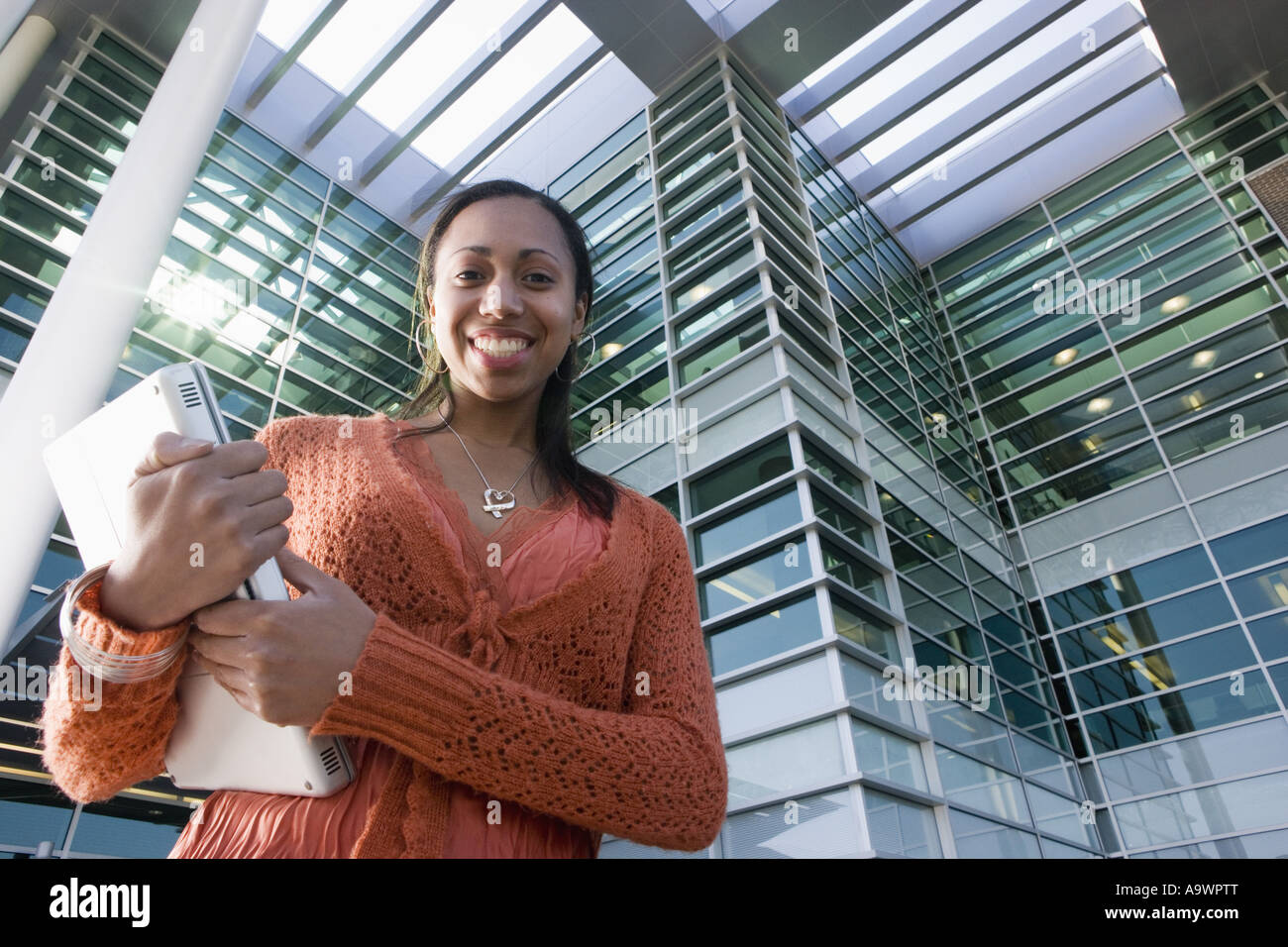 University student standing outside campus building Stock Photo - Alamy