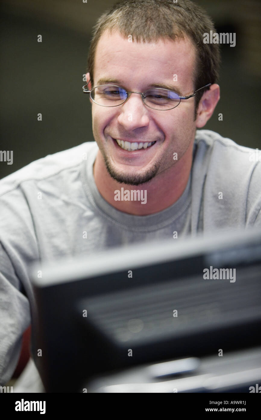 Young man sitting in front of a computer monitor and smiling Stock ...