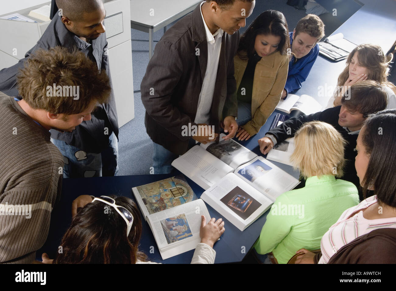 Students and teacher reading books in the classroom Stock Photo - Alamy