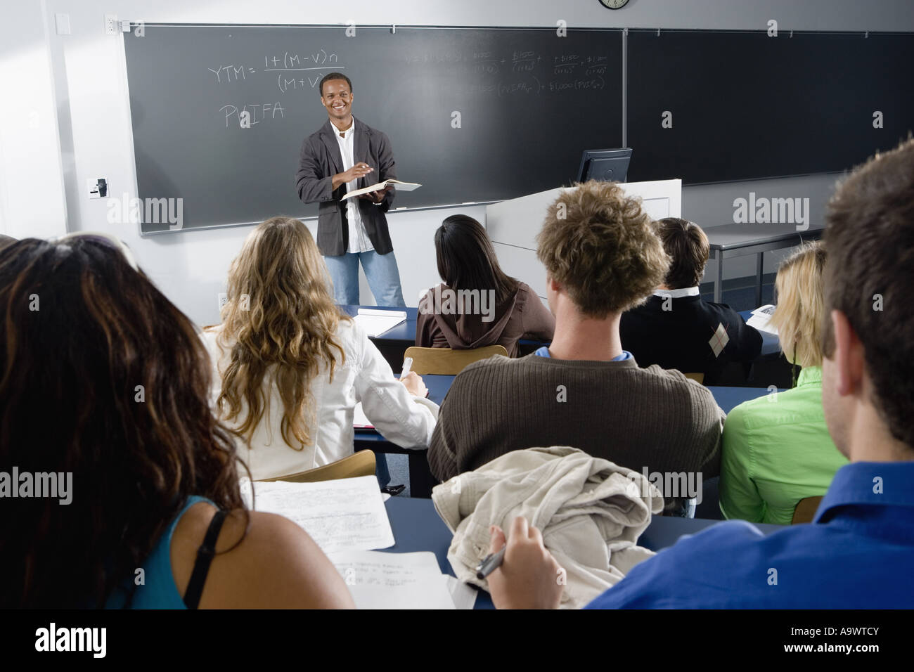 Teacher teaching students in the classroom Stock Photo - Alamy