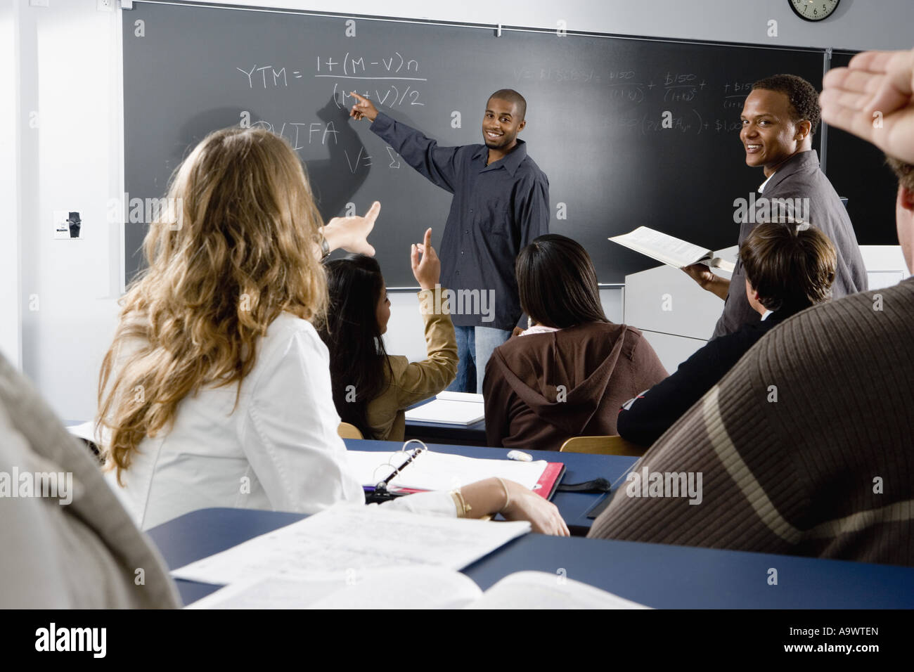 Teacher teaching students in the classroom Stock Photo - Alamy