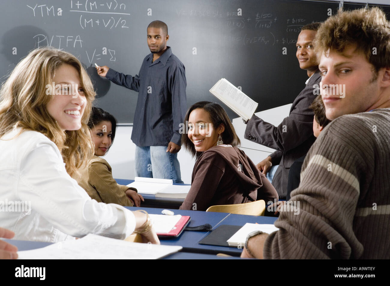 Teacher teaching students in the classroom Stock Photo - Alamy
