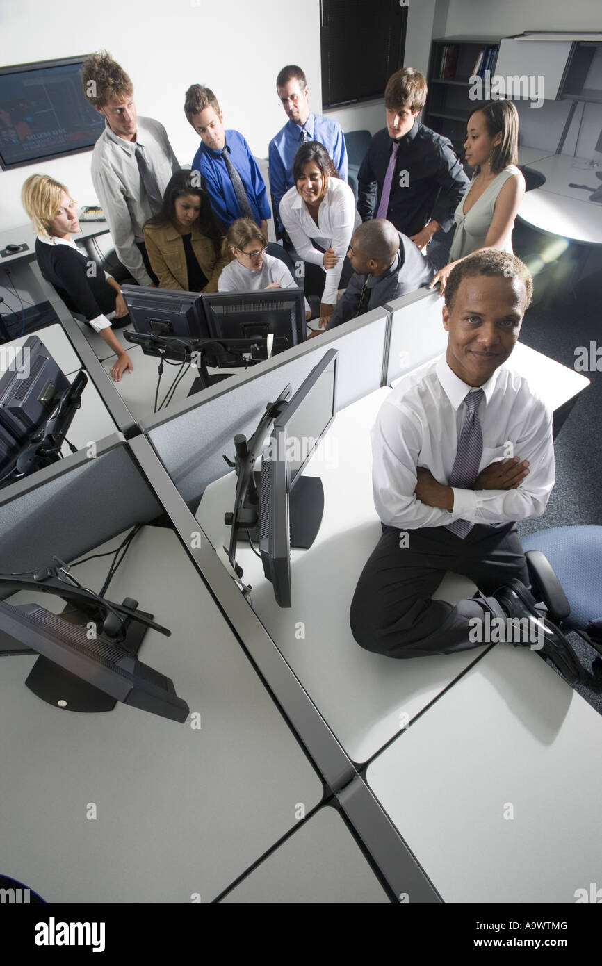 Group of young workers in office gathered around computer screen Stock ...