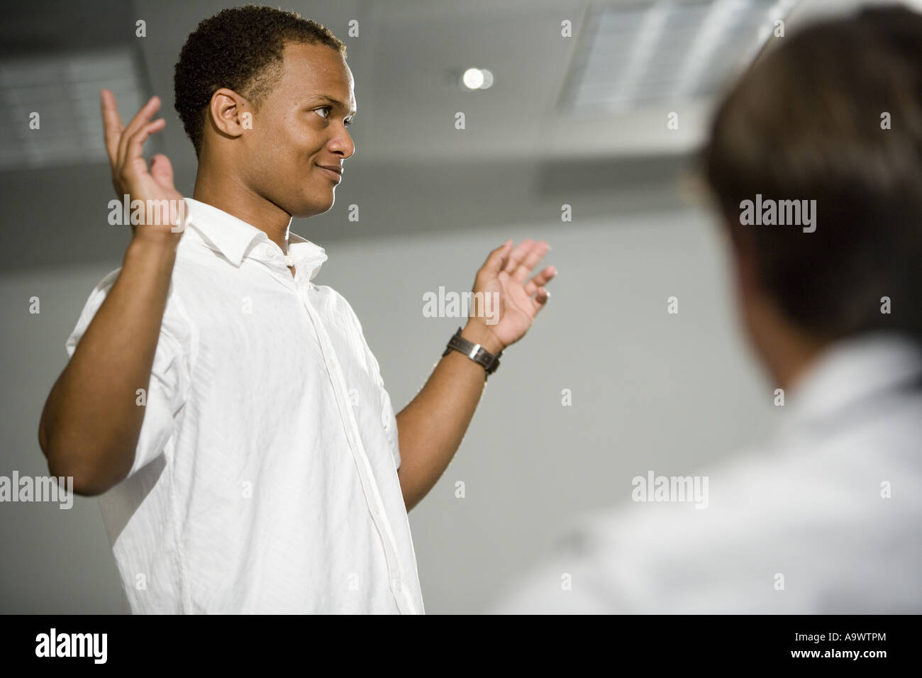 Teacher standing in the classroom gesturing towards class Stock Photo ...