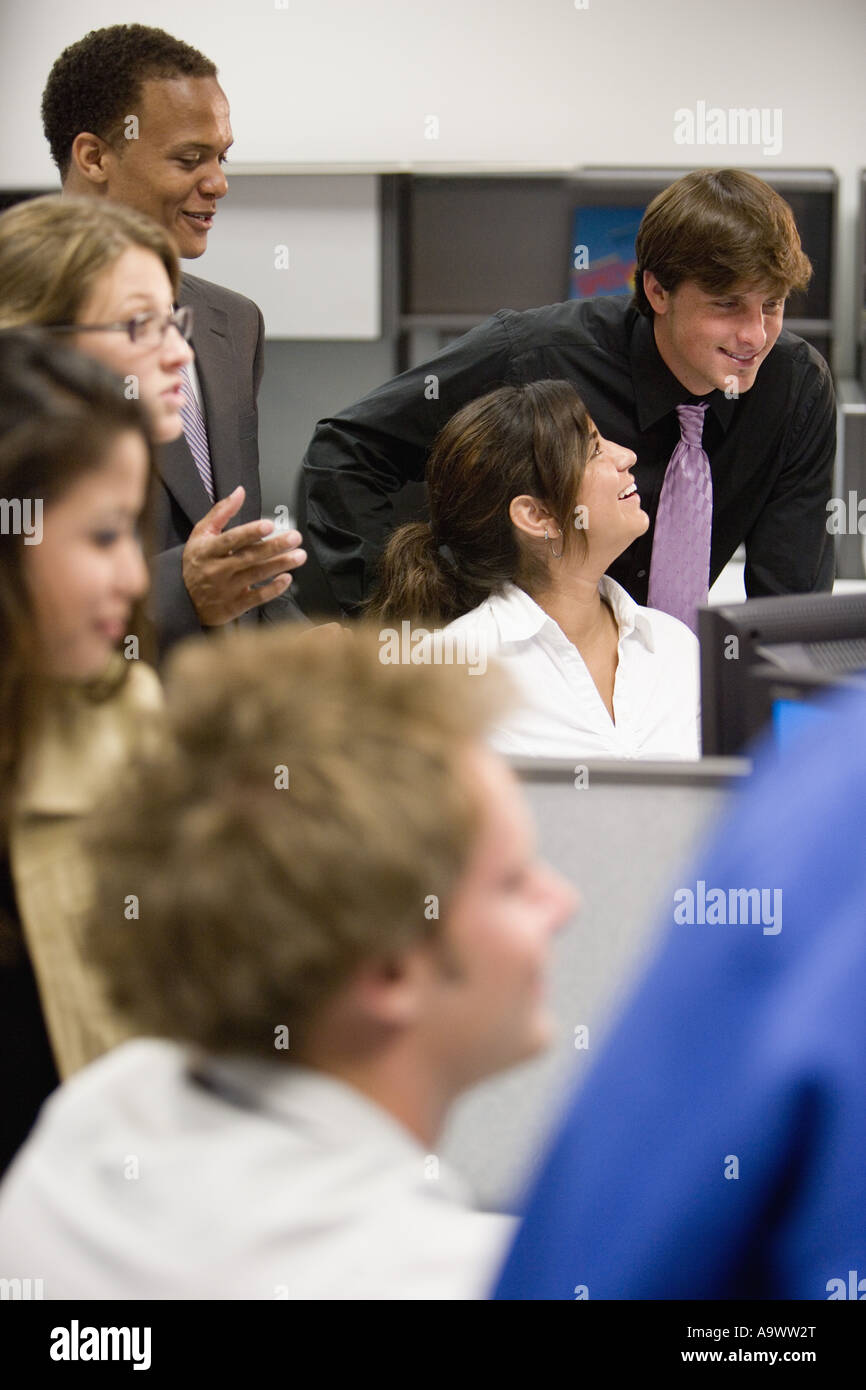 Close-up of office workers gathered around computer Stock Photo - Alamy