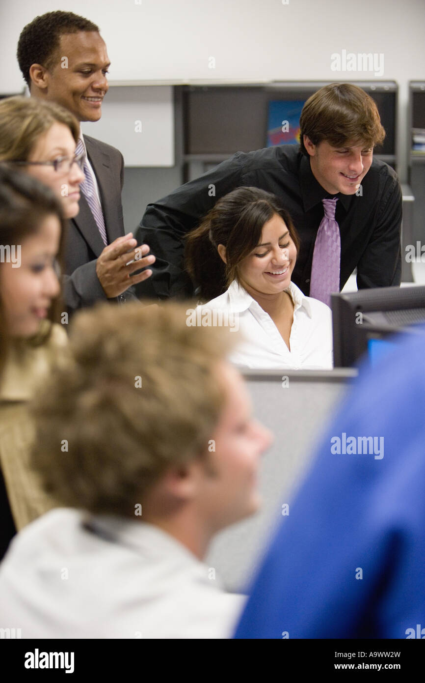 Close-up of office workers gathered around computer Stock Photo - Alamy