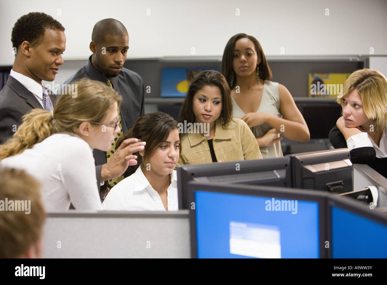 Close-up of office workers gathered around computer Stock Photo - Alamy