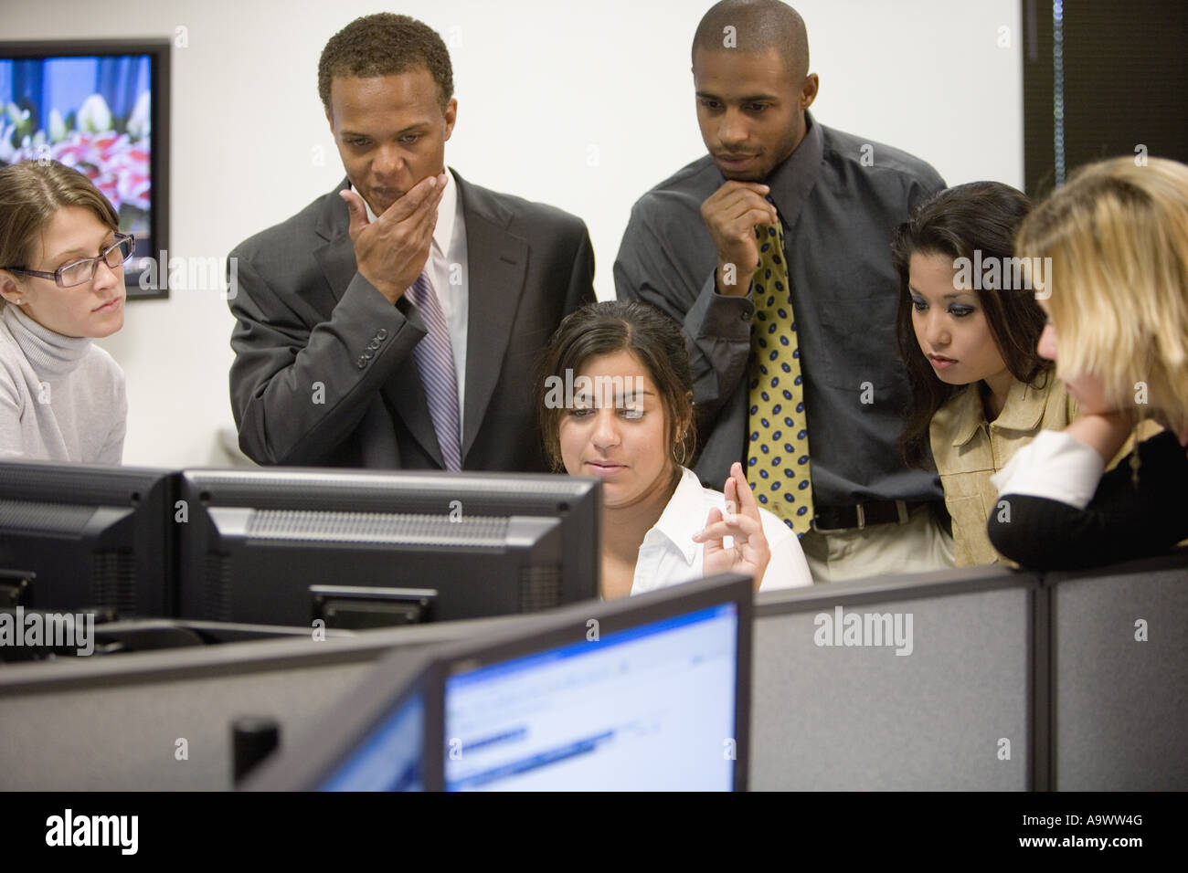 Close-up of office workers gathered around computer Stock Photo - Alamy