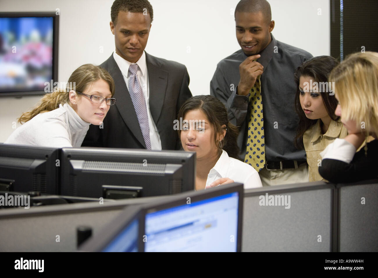 Close-up of office workers gathered around computer Stock Photo - Alamy