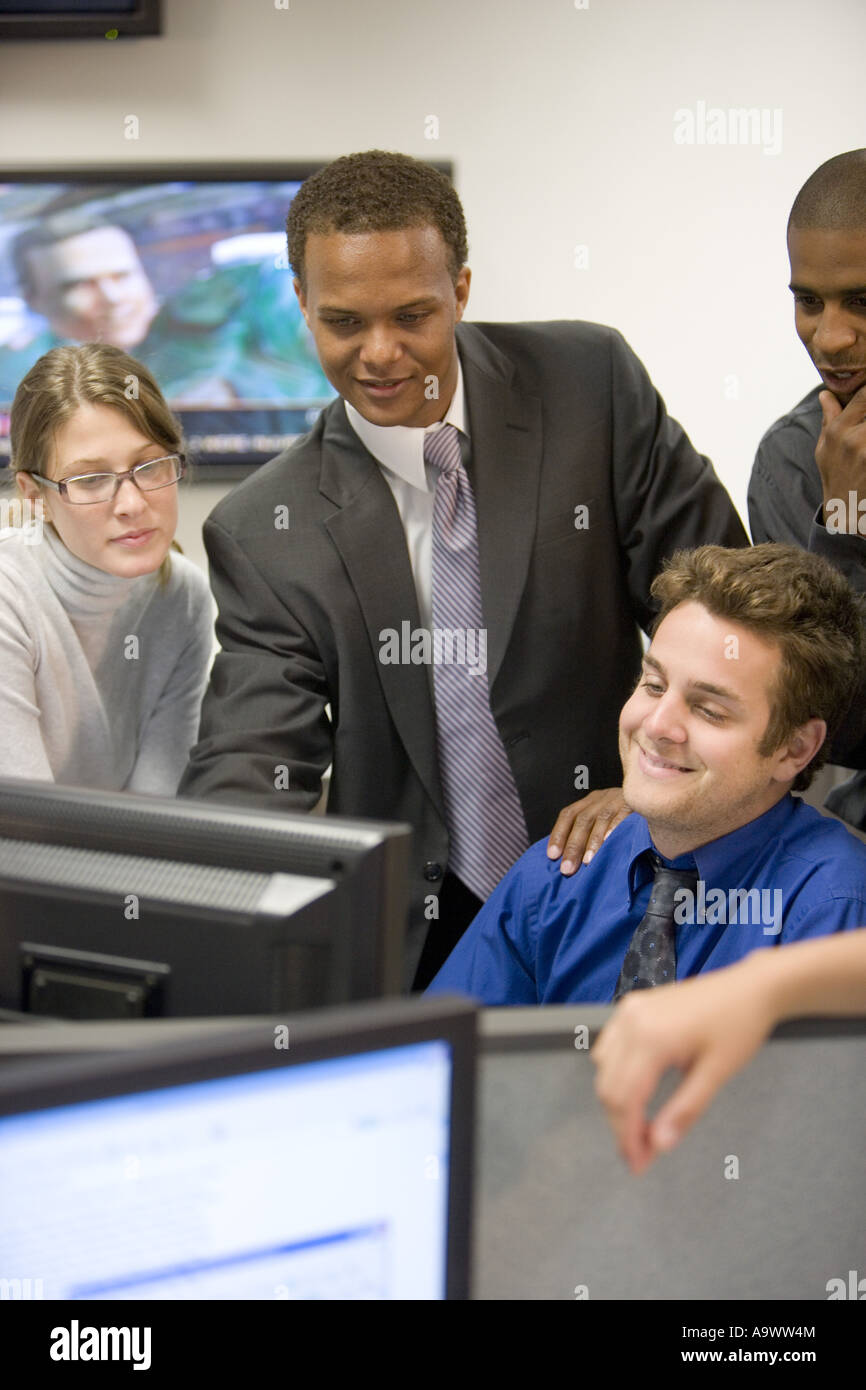 Close-up of office workers gathered around computer Stock Photo - Alamy