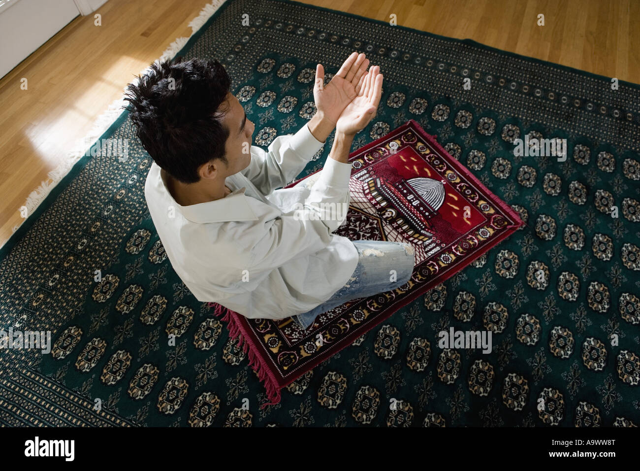 A Muslim man praying on a prayer mat Stock Photo - Alamy