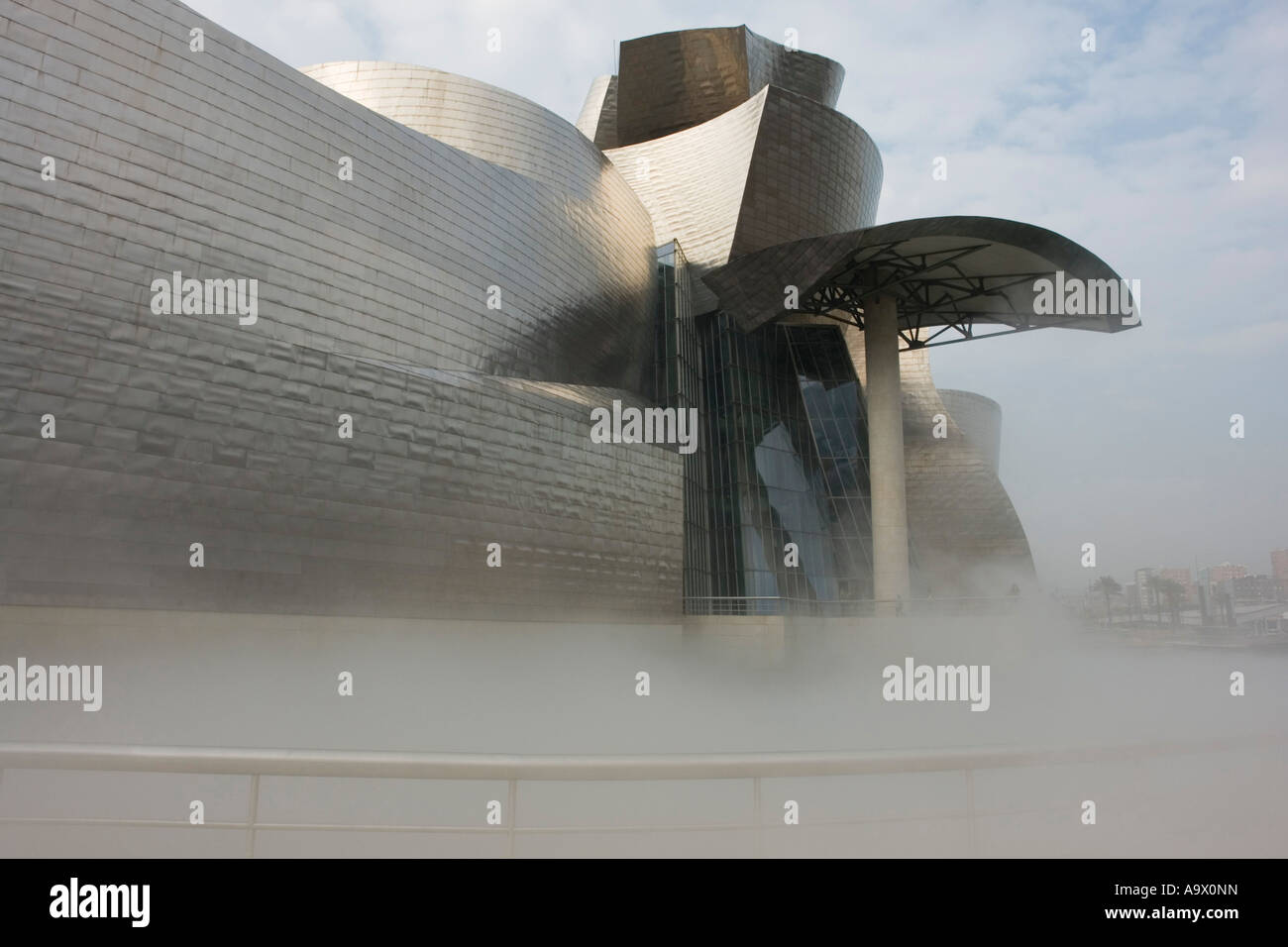 titanium clad walls of the Guggenheim Museum rise from the mist Bilbao ...