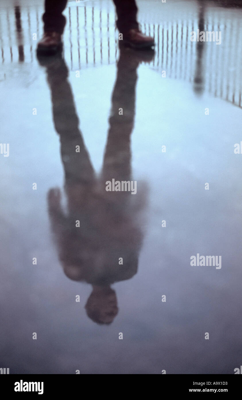 Man standing on wet ground reflection strong pose low section Stock ...