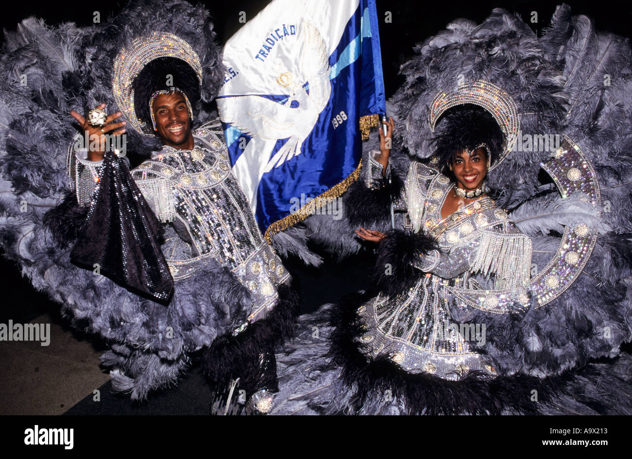 Rio de Janeiro, Brazil. Smiling man and woman in blue grey feather and ...