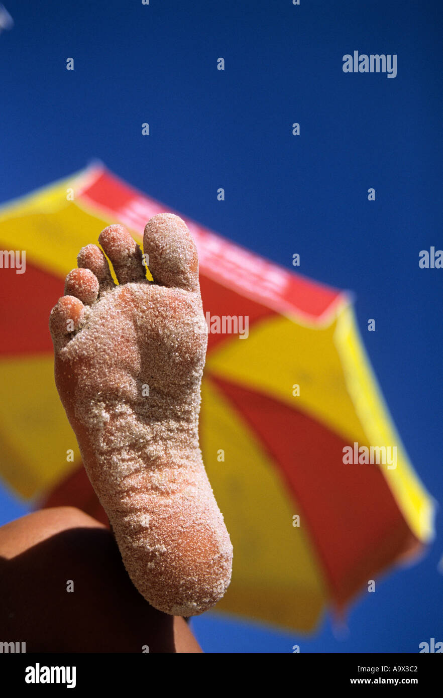 Rio de Janeiro, Brazil. A sandy foot against a parasol on the beach on ...