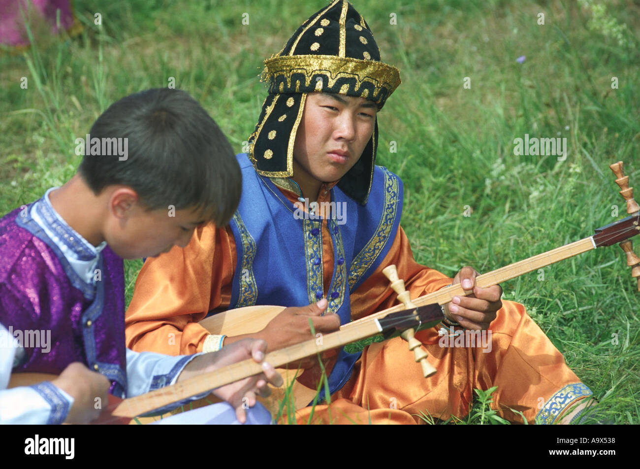 Man in Altaic costume is playing national music instrument topshur and ...
