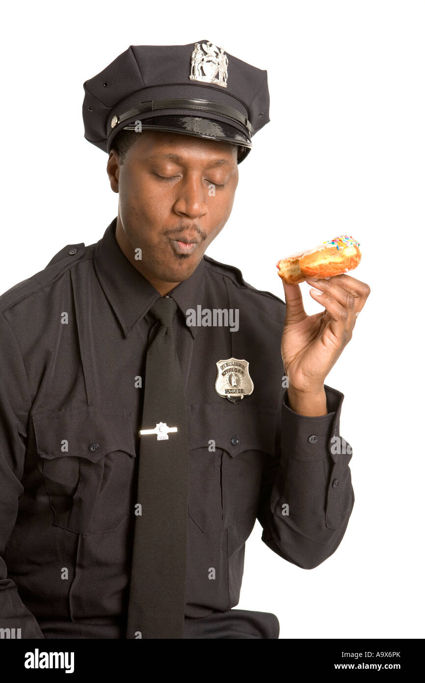 Policeman savouring the taste of a delicious donut in full uniform ...