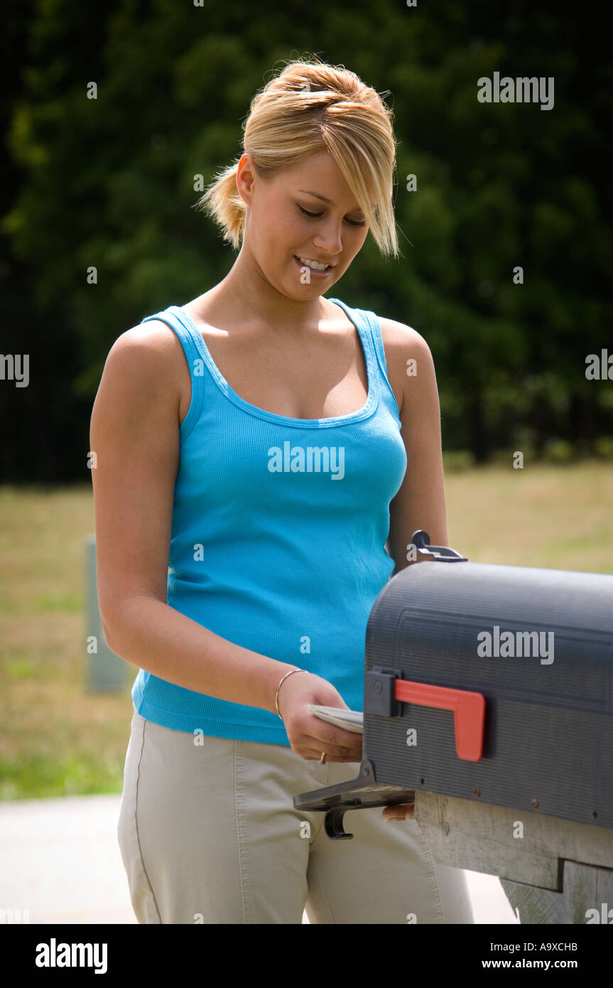 Woman getting mail from mailbox Stock Photo - Alamy