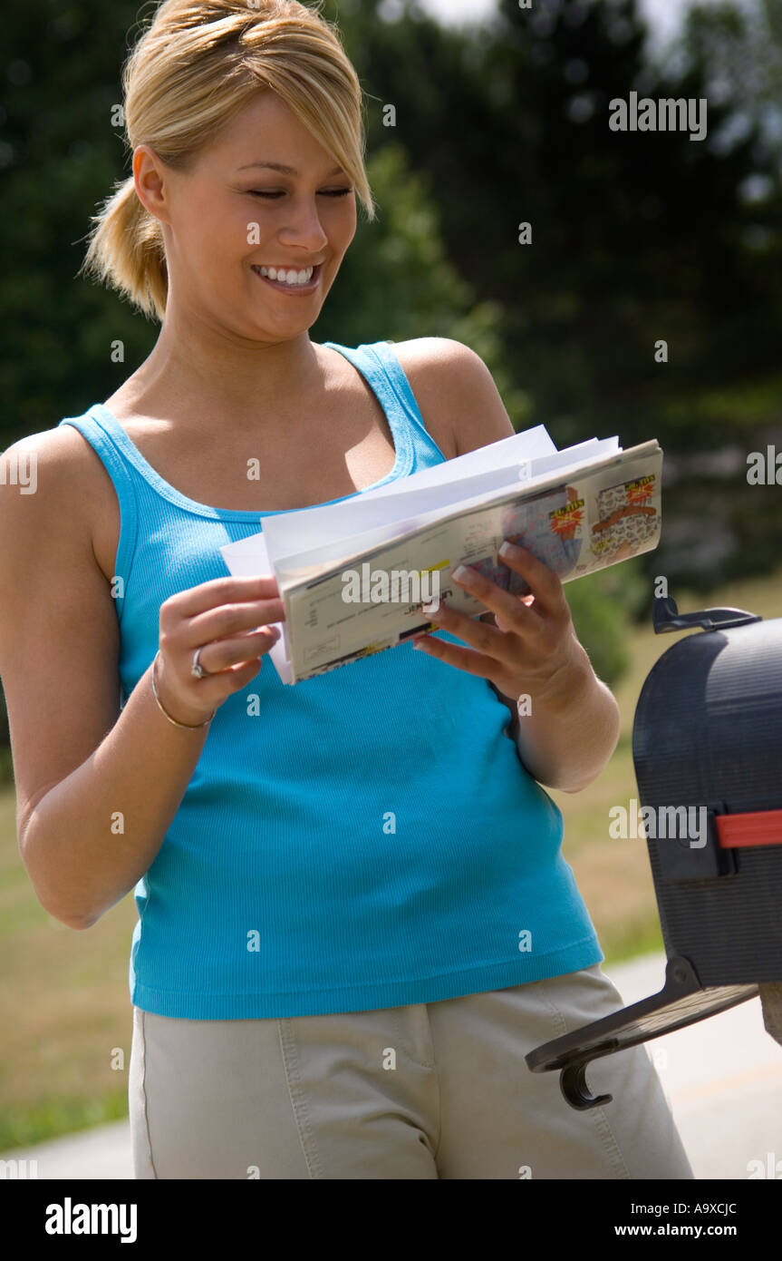 Woman getting mail from mailbox Stock Photo - Alamy