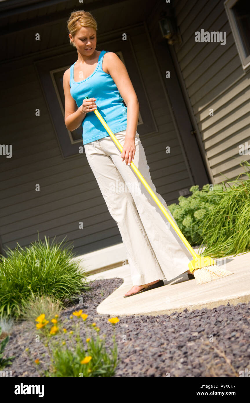Woman sweeping yard hi-res stock photography and images - Alamy
