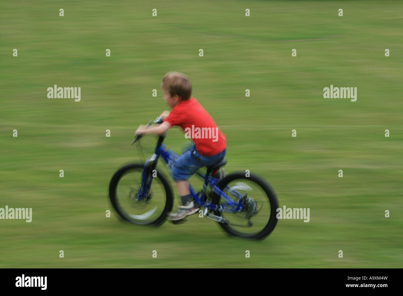 Young boy riding a bike Stock Photo - Alamy