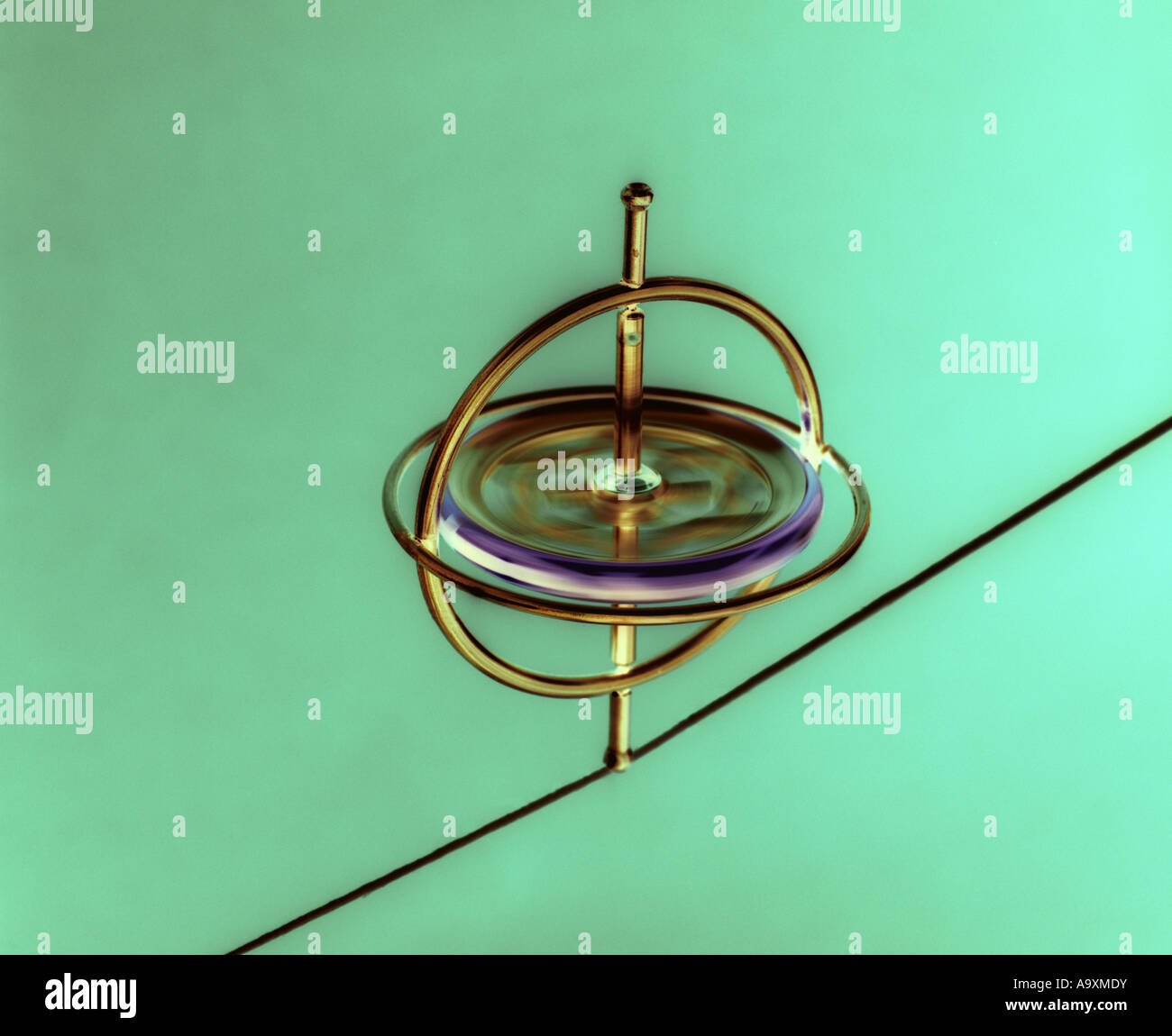 SPINNING GYROSCOPE BALANCES SUSPENDED ON STRING RED BACKGROUND Stock ...