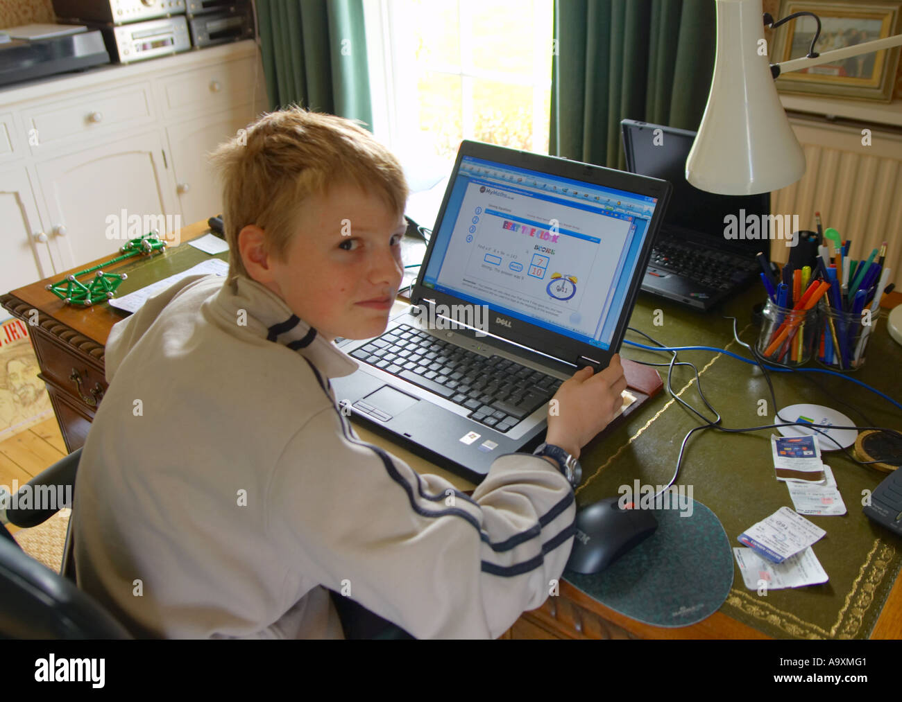 boy sitting at home at desk with laptop computer Stock Photo - Alamy