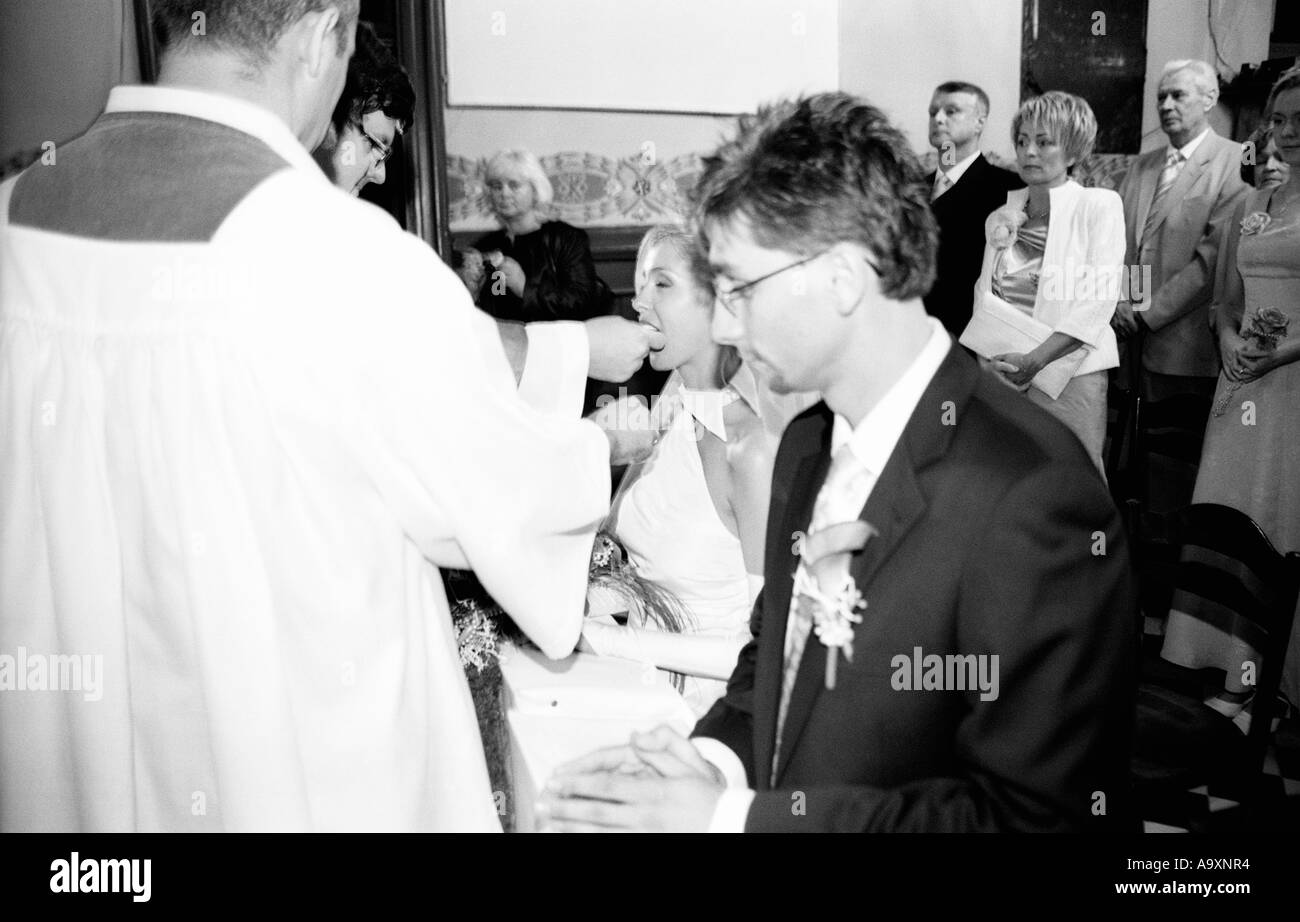 Poland, Lodz, bride and groom kneeling in church, receiving communion ...
