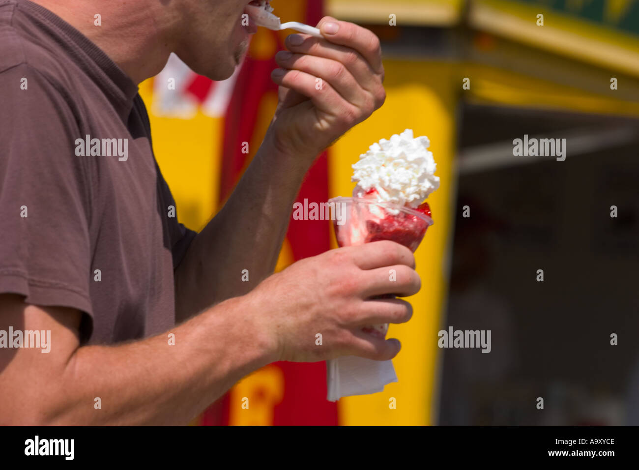 Man at a fair eating a whipped cream covered dessert with a spoon Stock ...