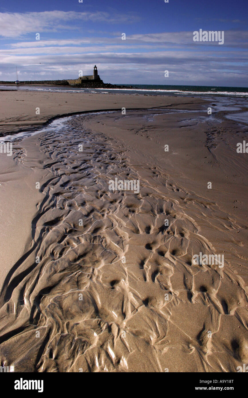 View across sand to Port Logan lighthouse and harbour wall the setting ...