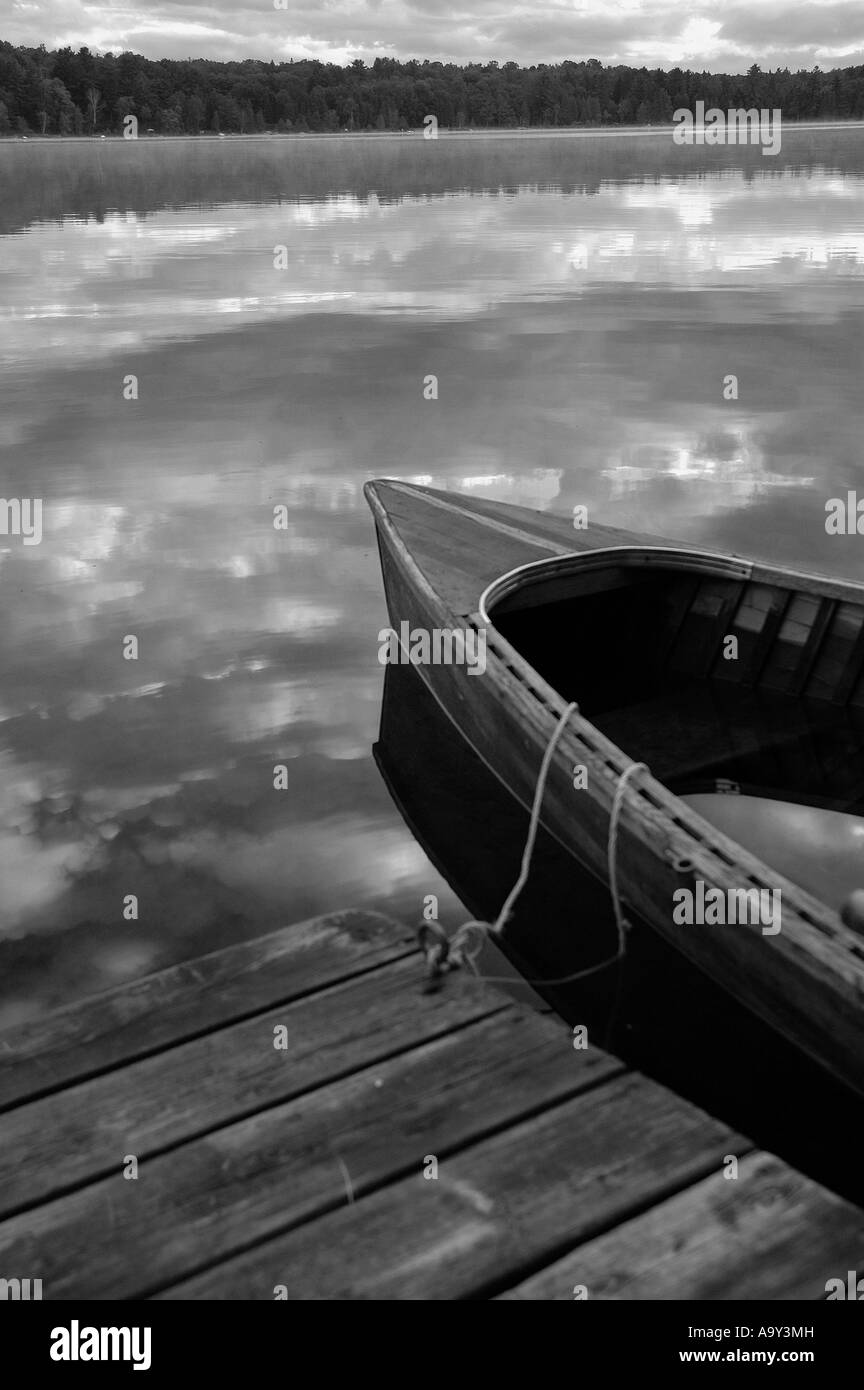 Empty Canoe On Shore with Cloud Reflection in Water Stock Photo - Alamy