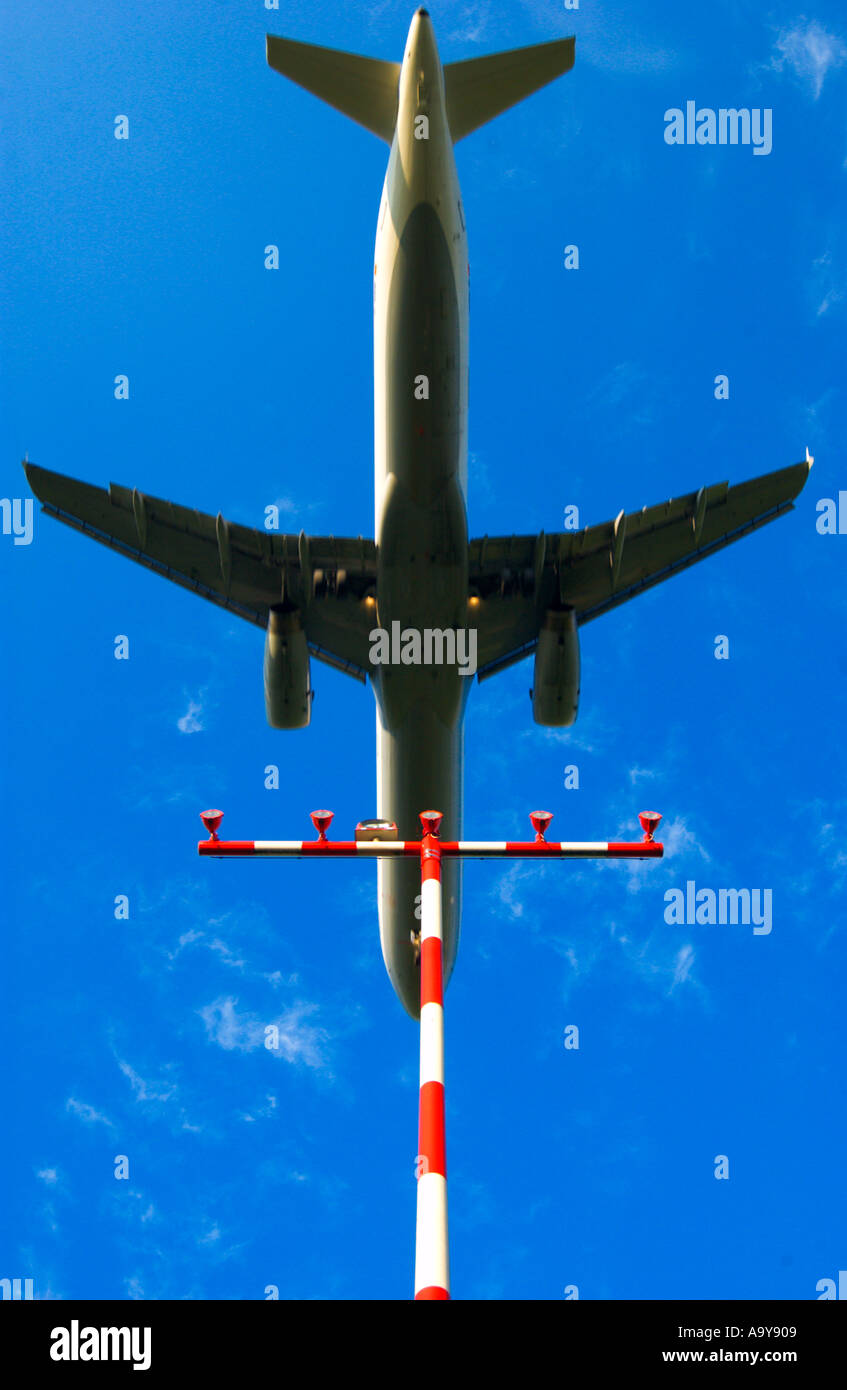 Passenger Plane flying over airport positioning lights Stock Photo - Alamy
