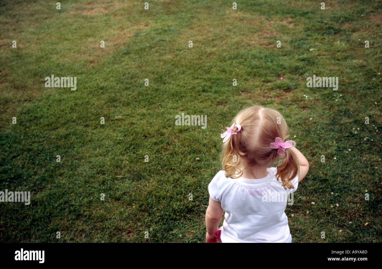 Young girl looks out over lawn in English country house garden Isle of ...