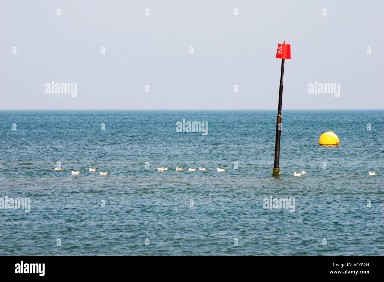 Sea marker post and yellow buoy Stock Photo - Alamy