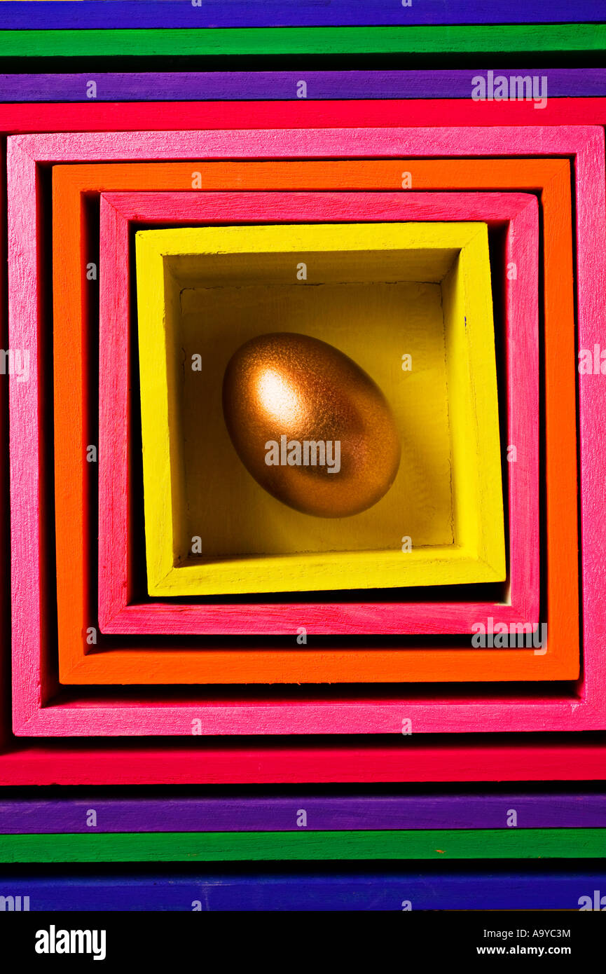 Golden egg in colored wooden boxes Stock Photo - Alamy