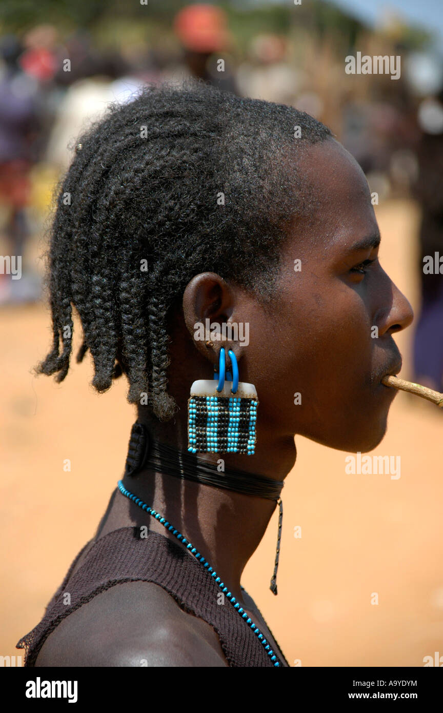 Young man in side profile with rasta hairstyle and ear adornment market ...