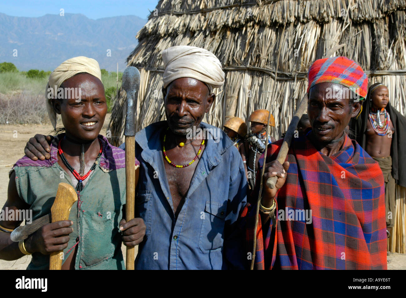 Three men of the Arbore people wearing different head dresses in front ...