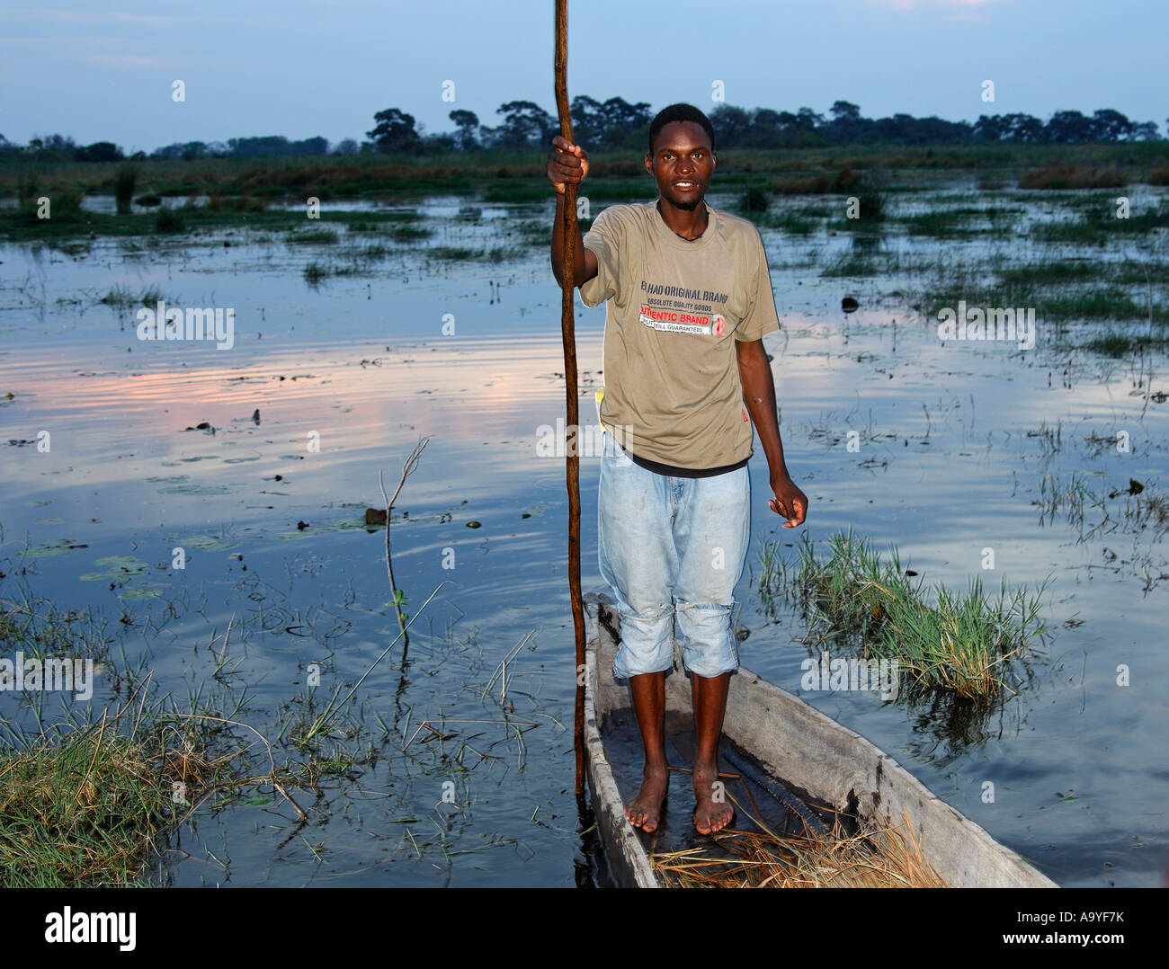 Local Bayei young man in the tradiional mokoro dugout boat, Okavango ...