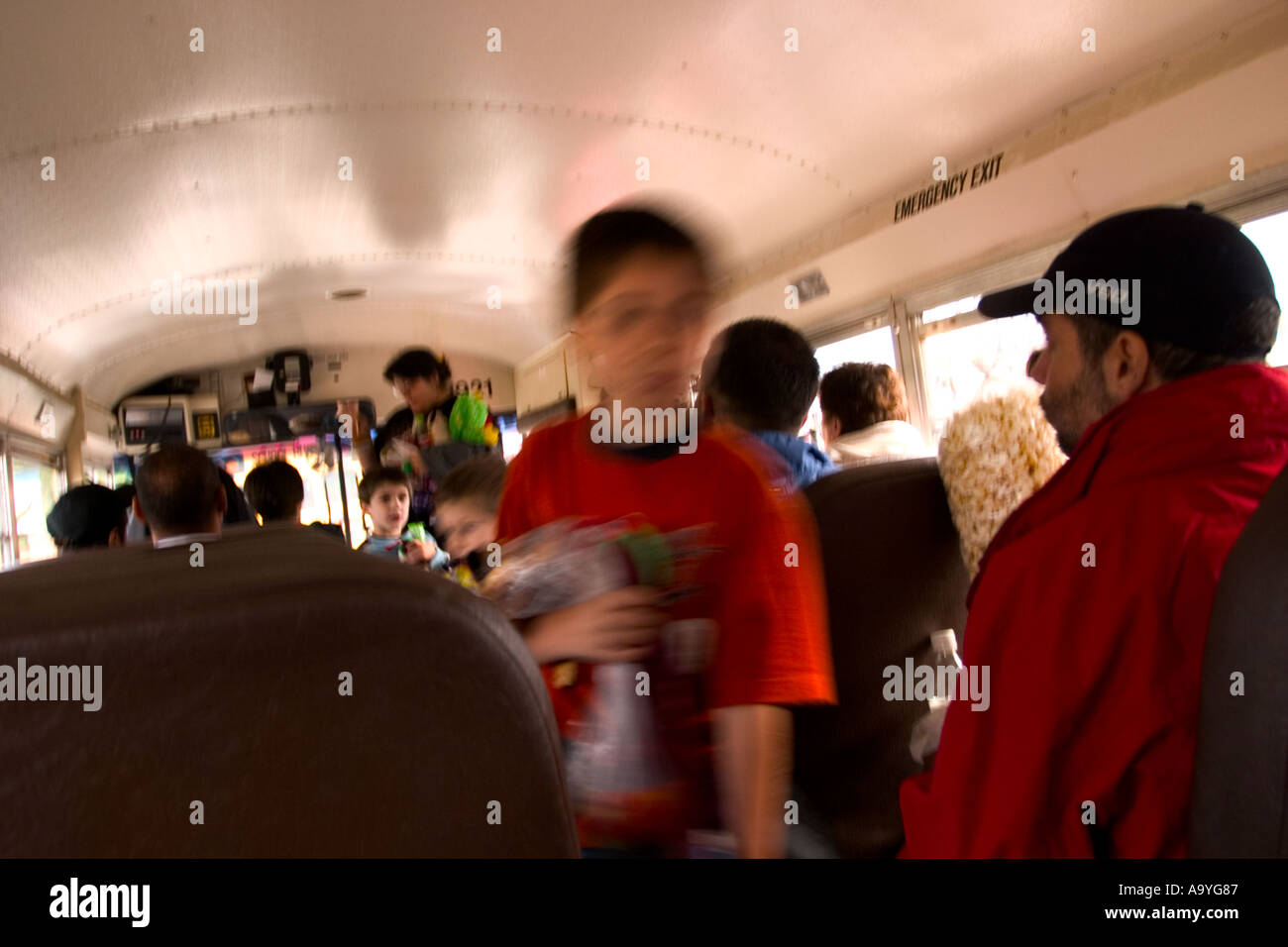 Young children at a fair inside a school bus walking towards the back ...