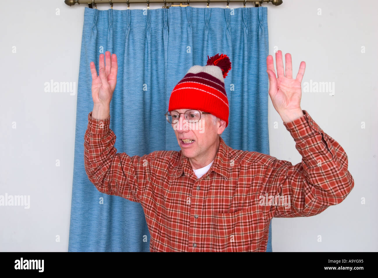 Middle age balding man with glasses wearing a wool hat standing and ...