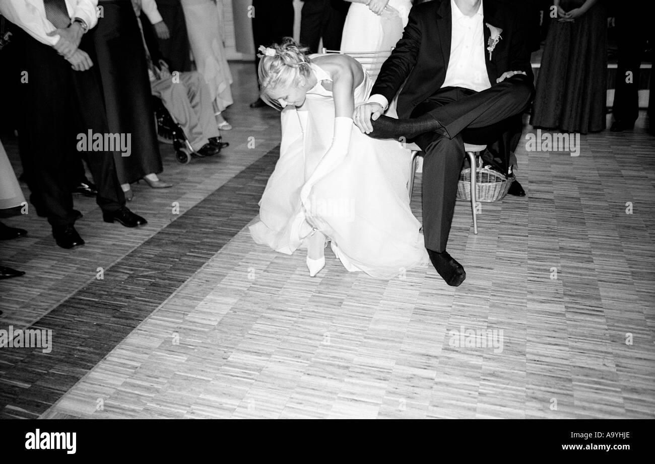 Poland, Lodz, bride and groom taking off shoes at wedding party (B&W ...