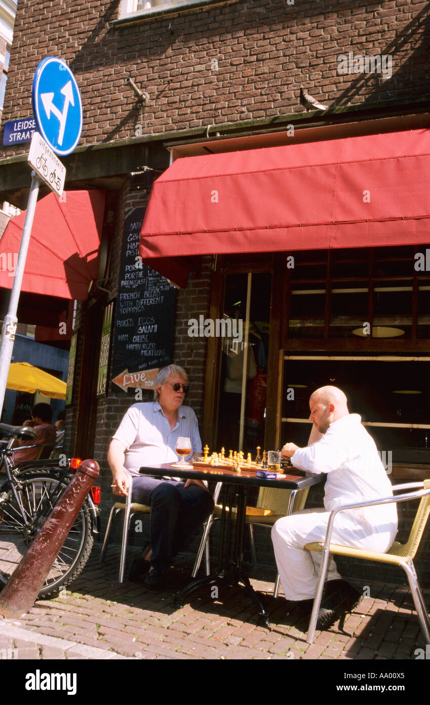 Netherlands, Amsterdam, mature men sitting in outdoor cafe, playing ...