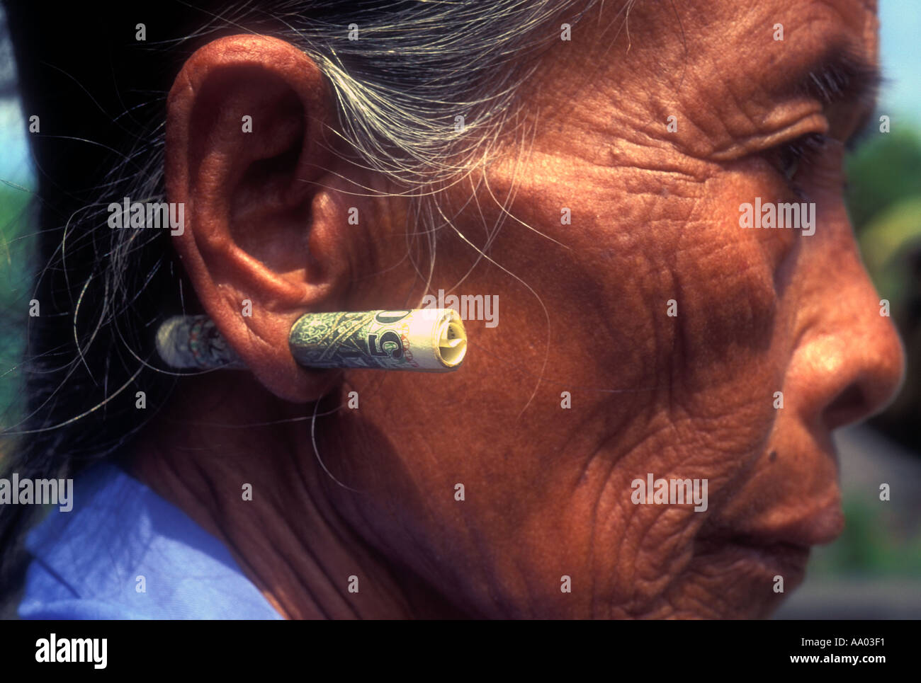 Woman with rolled money in her ear lobe Bali Indonesia Southeast Asia ...