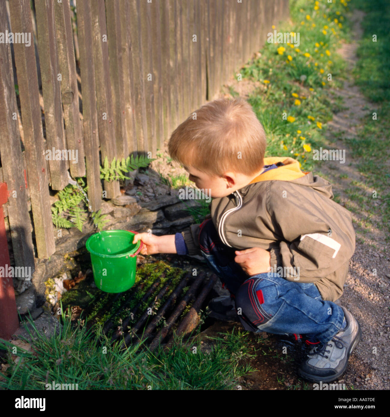Child playing with bucket of water hi-res stock photography and images ...