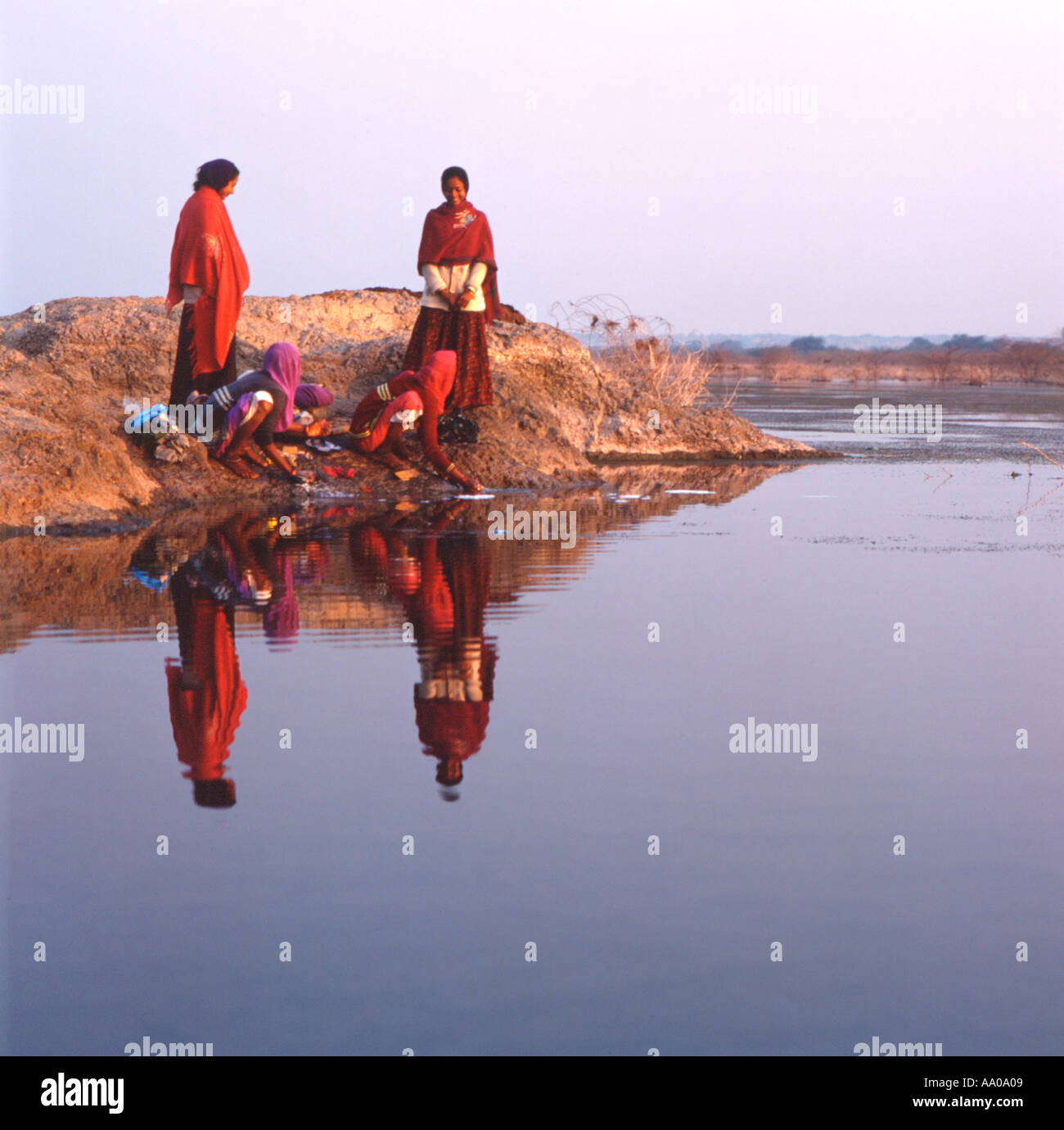 Three Indian village women washing clothes by the river bank Stock ...