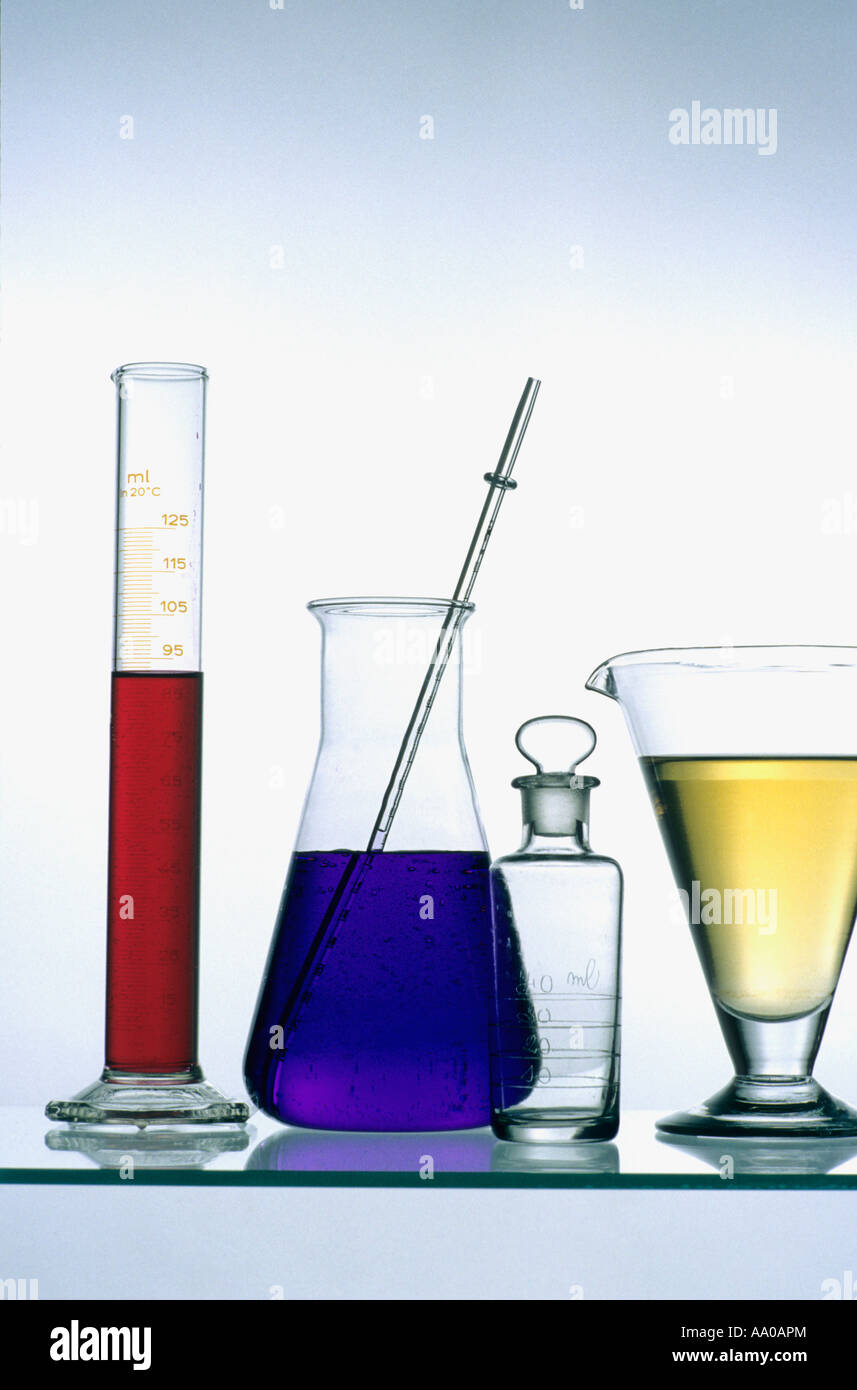 Brightly colored laboratory glassware displays a red liquid in a ...