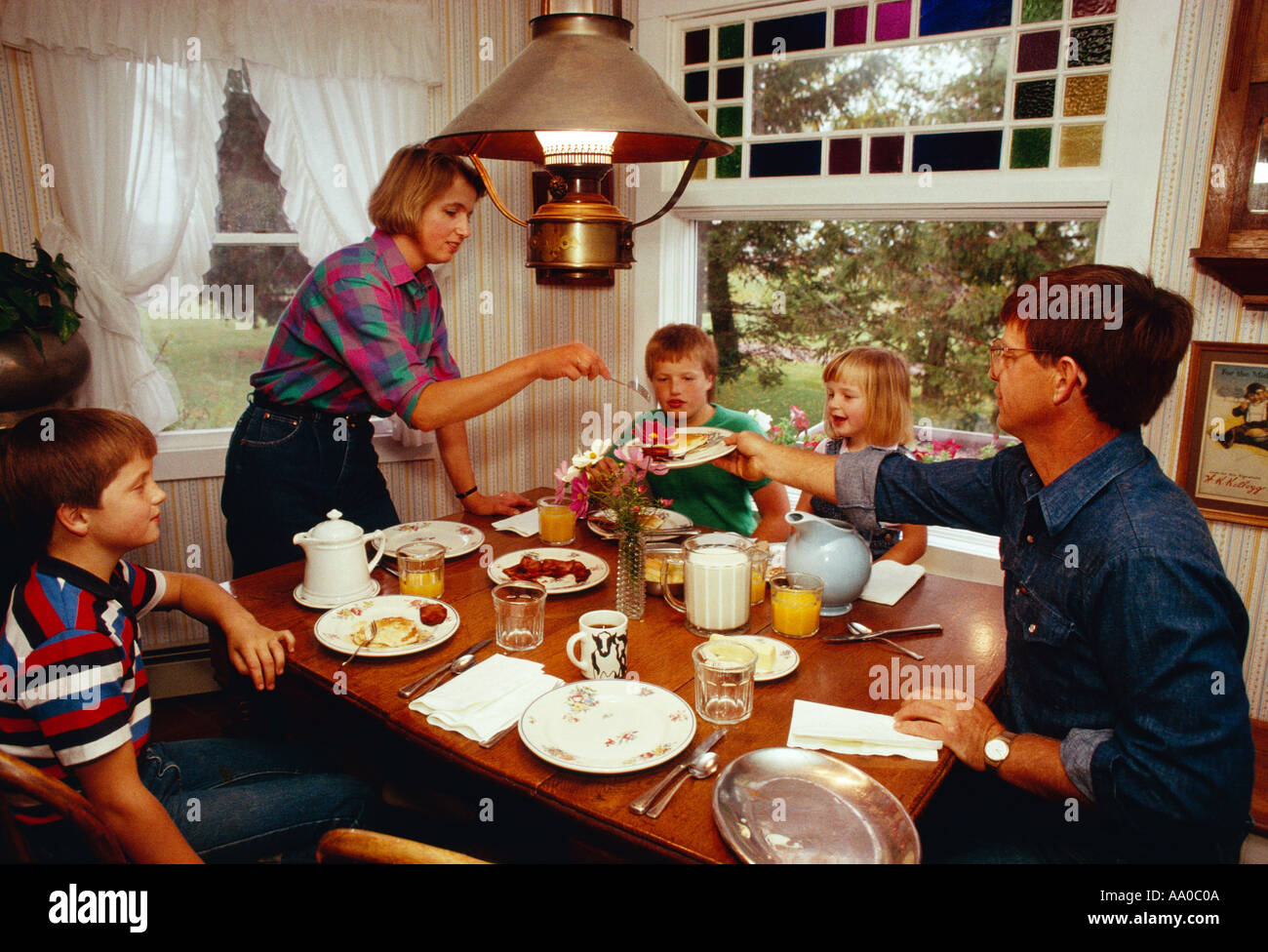 Agriculture - A farm family enjoys an early breakfast together prior to ...